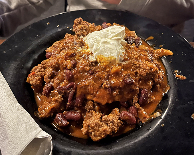Behold the legendary chili in all its glory—a bubbling cauldron of beefy goodness topped with a cool island of sour cream.