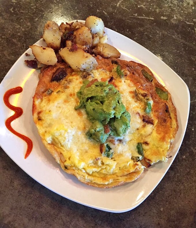 The Chorizo Frittata arrives like a work of art—a golden canvas of eggs topped with creamy avocado and surrounded by perfectly seasoned potatoes.