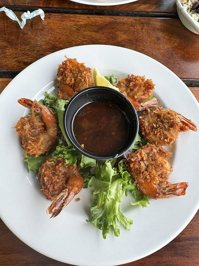 Golden-fried coconut shrimp arranged like a delicious clock around a dipping sauce—time stands still when food looks this good.