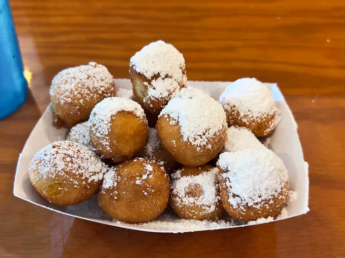 These corn fritters arrive dusted with powdered sugar like little golden meteorites of sweetness that somehow pair perfectly with seafood.