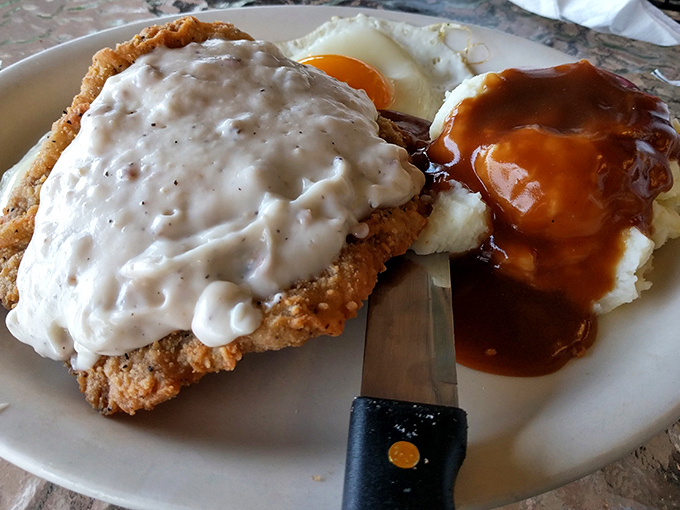 Country fried steak smothered in gravy alongside eggs and mashed potatoes—the breakfast equivalent of a warm hug from your favorite aunt.