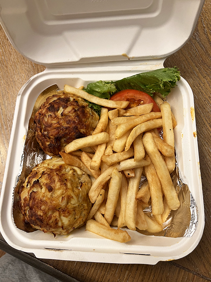 Behold the holy grail of Maryland cuisine: two golden-brown crab cakes with barely enough binding to keep the sweet jumbo lumps together. Seafood poetry on a plate.