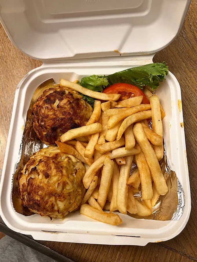 Behold the holy grail of Maryland cuisine: two golden-brown crab cakes with barely enough binding to keep the sweet jumbo lumps together. Seafood poetry on a plate.