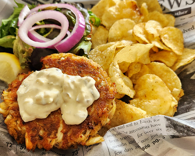 The golden-brown crab cake arrives like Neptune's gift – minimal filler, maximum crab, and a dollop of remoulade that whispers, "You made the right choice."