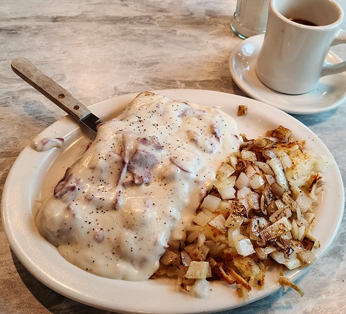 Behold the star attraction: cream chipped beef that blankets the toast like a warm hug, with crispy home fries standing by for the perfect bite combination.
