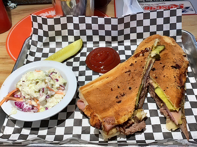 Cuban Sandwich: Architecture in sandwich form—layers of slow-roasted pork, ham, and pickle creating perfect structural integrity while that side of coleslaw provides a cooling counterpoint.