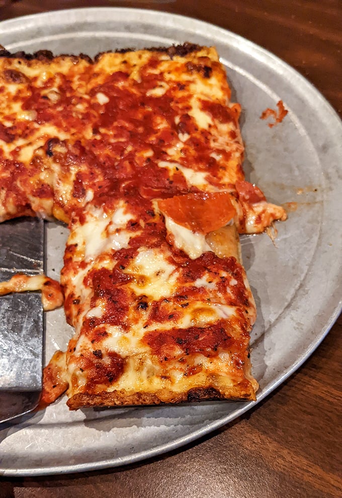 That glorious caramelized cheese edge is pizza's equivalent of hitting the jackpot—crispy, chewy, utterly irresistible Detroit-style magic.
