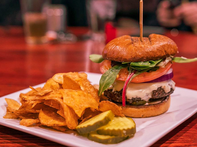 This isn't just a burger; it's an architectural marvel of beef, cheese, and fresh veggies. The house-made chips and pickle spear aren't sidekicks—they're essential supporting characters.