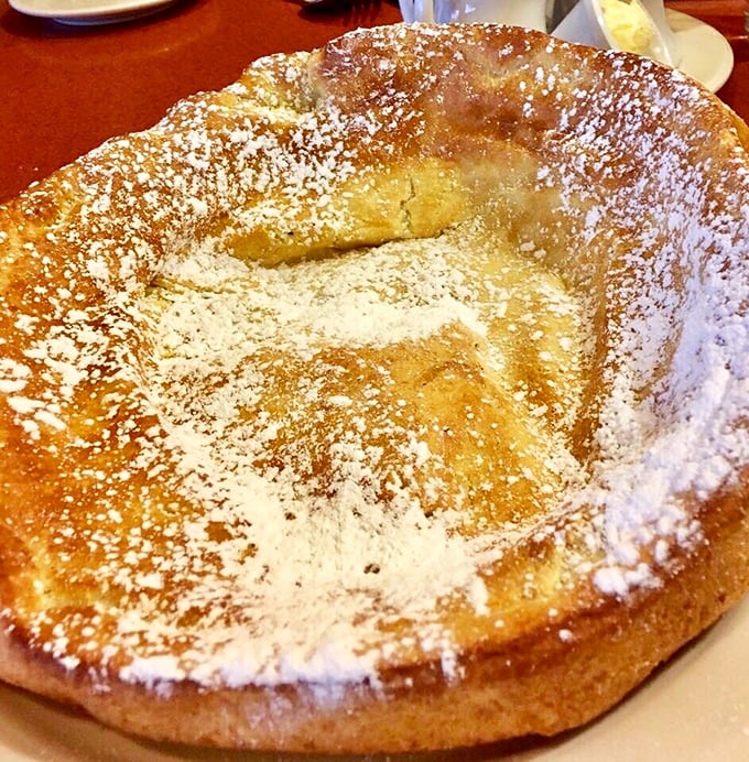 The famous oven-baked pancake rises like a golden soufflé, creating a crater perfect for filling with fresh fruit—breakfast as delicious theater.