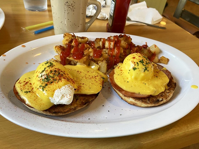 Eggs Benedict done right is breakfast architecture—perfectly poached eggs balancing on their English muffin pedestals, draped in hollandaise gold.