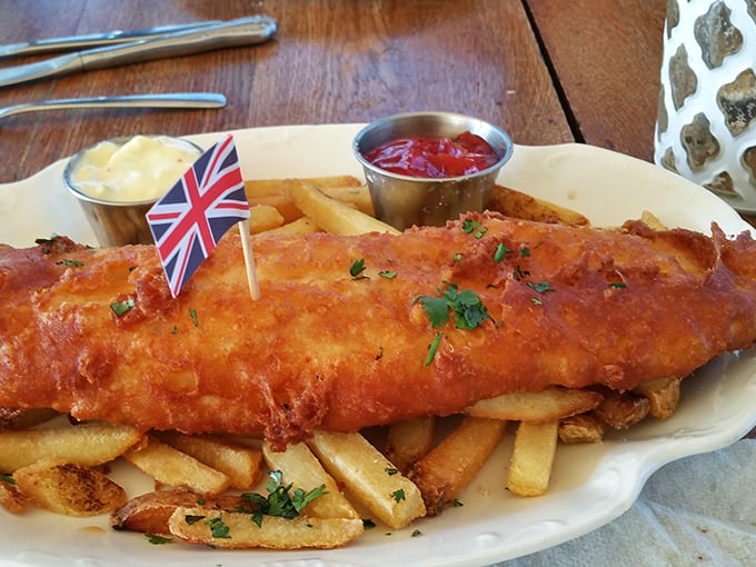 The star of the show arrives with its own tiny Union Jack – golden, crispy fish atop hand-cut chips that would make London proud.