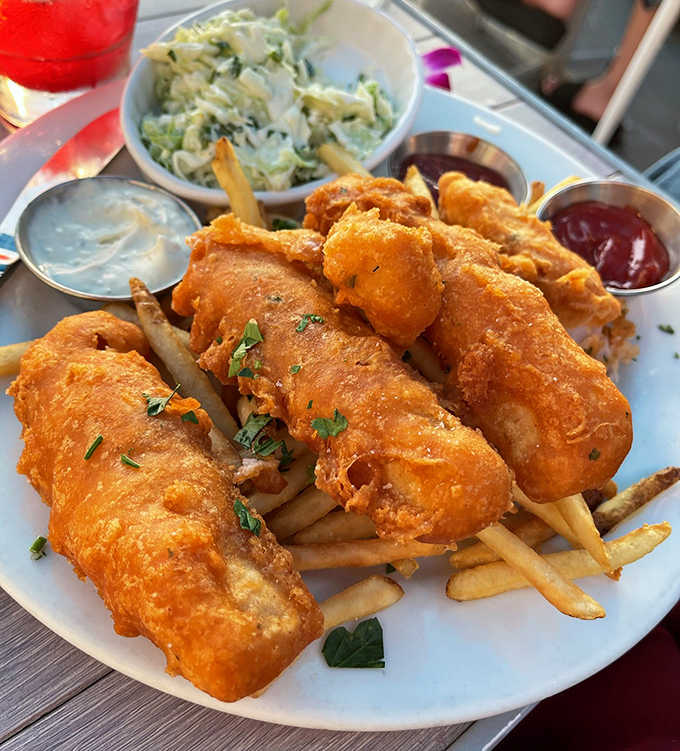 Golden-battered fish perched atop crispy fries – this isn't just fish and chips, it's edible sunshine that crunches, the dish that launched a thousand local loyalties.