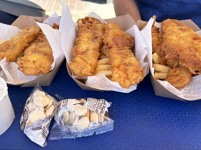 Golden-battered fish nestled atop crispy fries – the kind of comfort food that makes you wonder why anyone bothers with fancy dining.