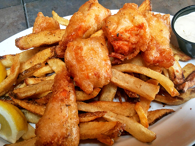 Golden-battered fish perched atop hand-cut fries – the kind of plate that makes you forget your table manners and dive in headfirst.