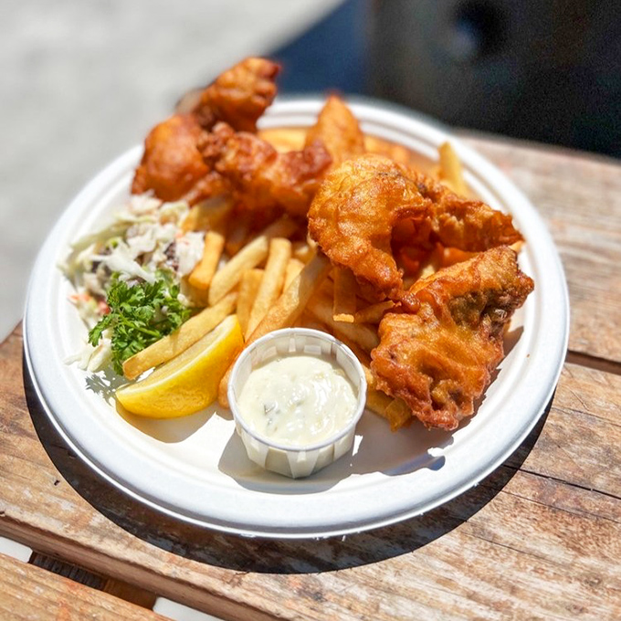 Golden-battered fish that shatters with each bite, alongside perfectly crisp fries. This isn't just fish and chips—it's edible sunshine on a plate.