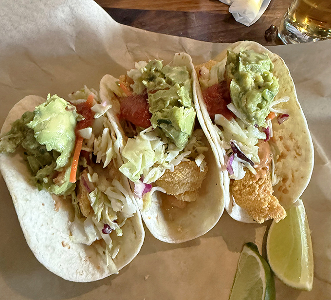 These fish tacos don't just speak—they sing! Crispy beer-battered perfection topped with fresh slaw and avocado, with lime standing by for duty.