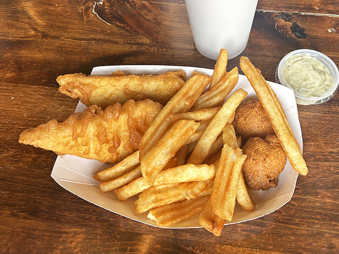 Golden-battered fish resting atop a mountain of hand-cut fries—the kind of basket that makes you wonder why anyone bothers with white tablecloths.