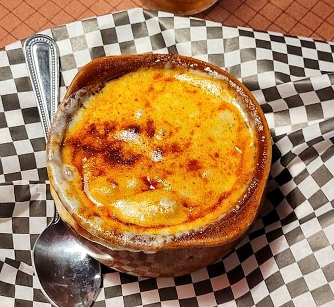 Behold the French onion soup in all its glory—a bubbling cauldron of cheese, broth, and happiness that's worth the trip alone.