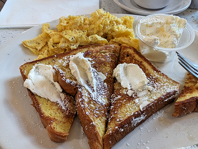 French toast nirvana achieved! Golden perfection topped with powdered sugar and cream—breakfast that's worth setting your alarm for.