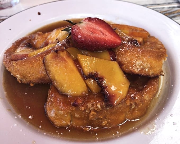 French toast that doesn't just break the fast—it shatters expectations. Golden-brown perfection swimming in syrup with fresh fruit that makes mornings worth facing.