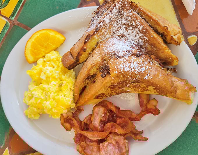 This French toast combo isn't just breakfast—it's a morning masterpiece with powdered sugar snow, golden scrambled eggs, and bacon that demands respect.