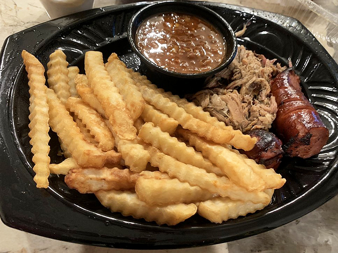 Those golden crinkle-cut fries aren't just a side – they're the perfect vehicle for sopping up that rich barbecue sauce and smoky meat juices.