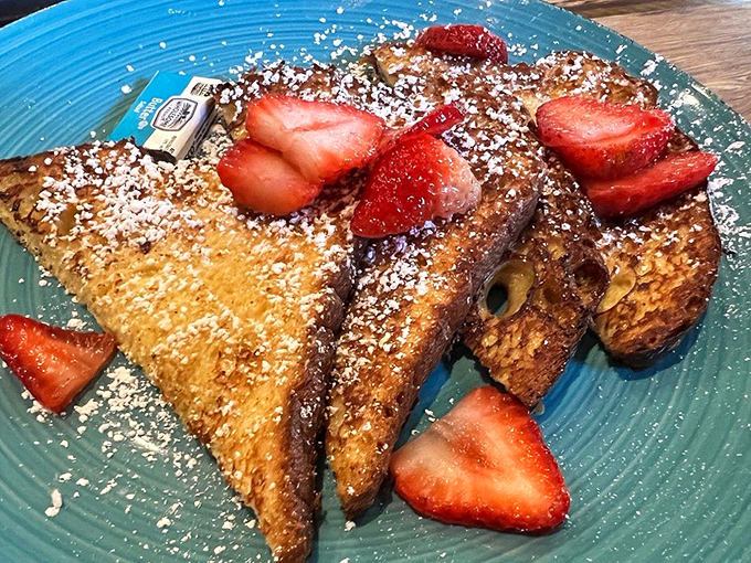 Golden-brown French toast that's achieved breakfast nirvana. Those fresh strawberries and powdered sugar aren't just toppings—they're the crown jewels.