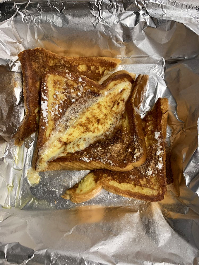 Golden-brown French toast dusted with powdered sugar—proof that sometimes the simplest pleasures are worth getting out of bed for.