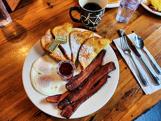 Golden-brown French toast dusted with powdered sugar alongside perfectly crisp bacon—breakfast's greatest hits album on a single plate.