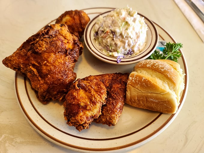 Golden-brown perfection meets creamy coleslaw and a fresh roll – this isn't just fried chicken, it's edible nostalgia on a plate.
