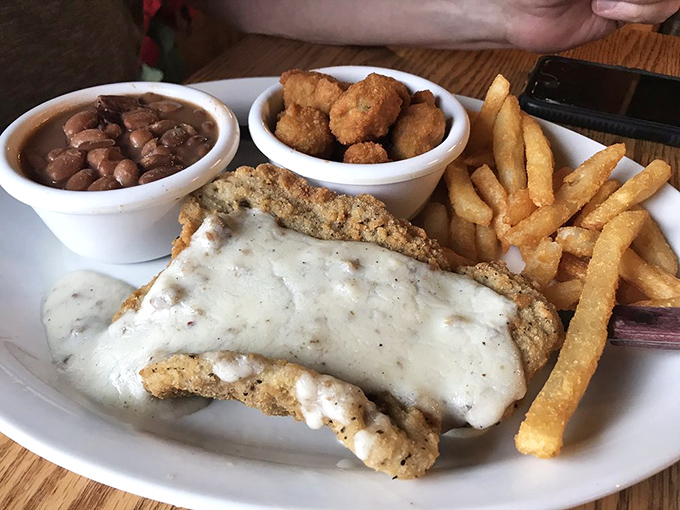 Country fried steak that's practically performing a balancing act on the plate. That pepper gravy doesn't just cover the meat—it completes it.