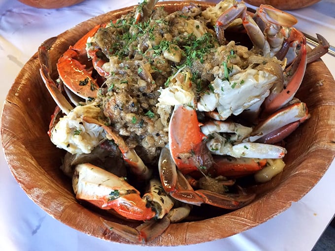 Garlic crabs arrive like a beautiful mess in a wooden bowl. This isn't first-date food unless you're ready to see someone's true crab-cracking character.