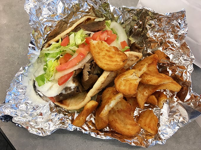 This isn't just a gyro, it's an edible work of art – perfectly crisp potatoes nestled beside a foil-wrapped package of Mediterranean bliss.