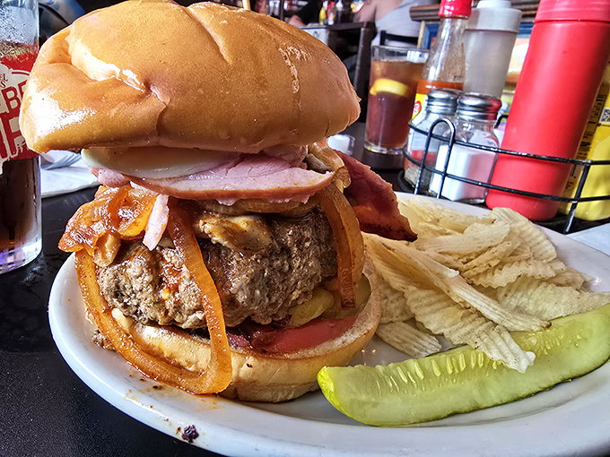 Architecture in burger form—layers of beef, cheese, and toppings creating a savory skyscraper that requires both hands and possibly engineering skills to consume.