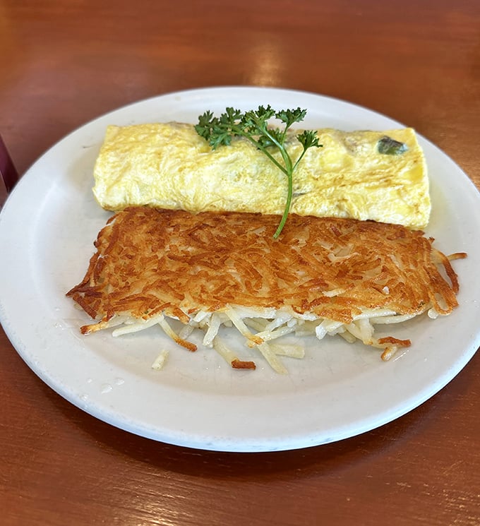 Behold the star of our show: those legendary hash browns with their golden exterior giving way to tender potato beneath—paired with an omelet that's equally camera-ready.