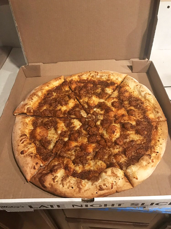 This isn't just a pizza—it's a commitment. The meaty masterpiece sits in its cardboard throne, practically daring you to finish it.