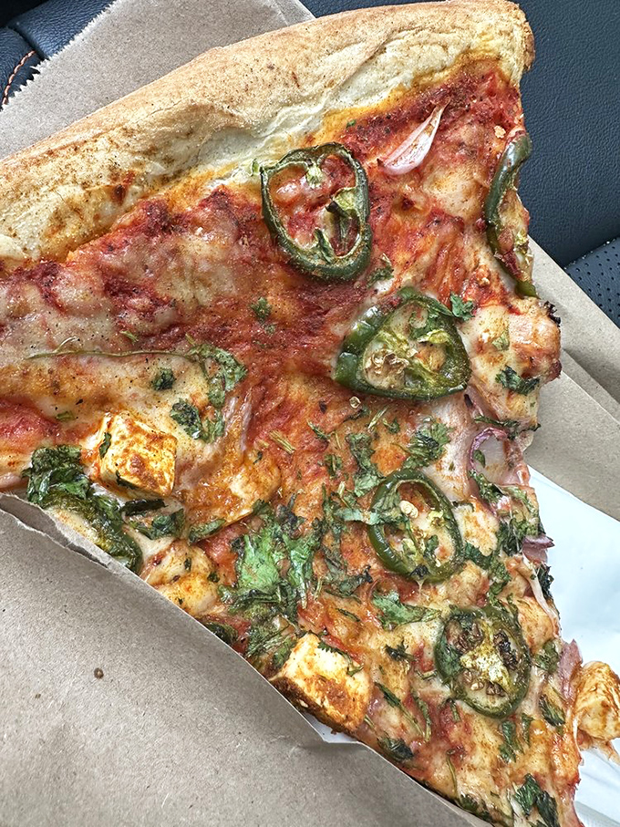 Pizza perfection with an identity crisis! Jalapeños, cilantro, and what appears to be paneer create a cross-continental masterpiece that shouldn't work but absolutely does.
