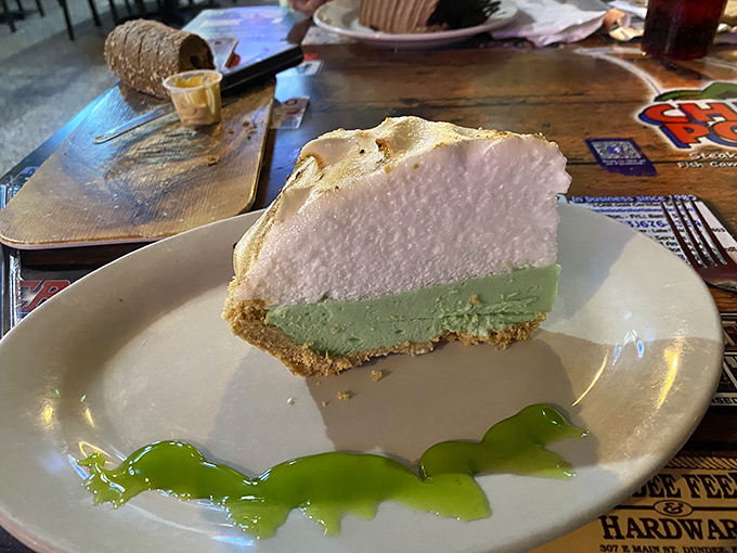 Behold the slice that launched a thousand road trips – key lime perfection with whipped cream clouds above.