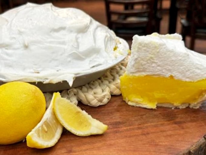 Sunshine-yellow filling crowned with clouds of meringue – this slice of lemon heaven isn't just dessert, it's a religious experience worth converting for.