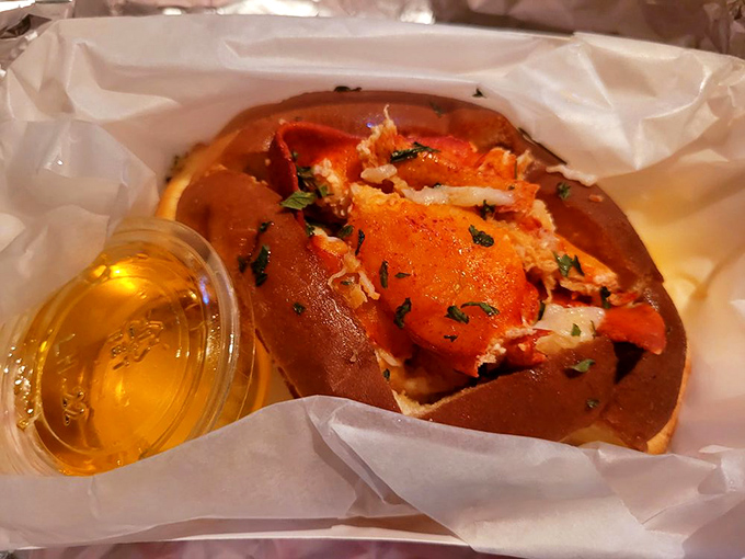 This lobster roll isn't messing around—chunks of sweet meat nestled in a buttery bun with a side of liquid gold. New England, eat your heart out.
