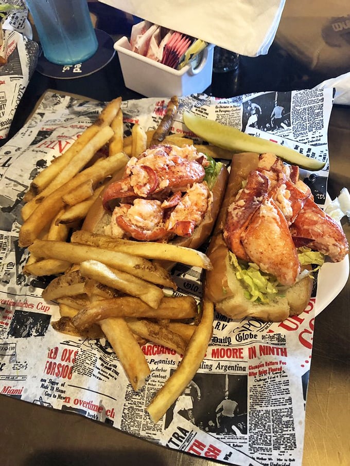 The lobster roll that launched a thousand road trips—chunks of sweet Maine lobster nestled in buttery perfection, served with golden fries on nostalgic newspaper.