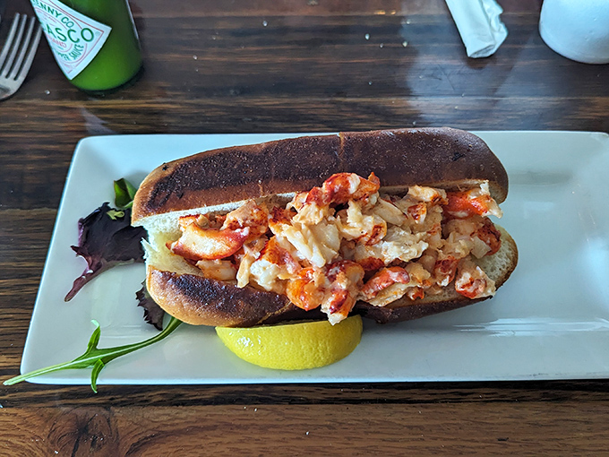 Behold the star attraction: chunks of sweet lobster meat nestled in a perfectly toasted roll—proof that sometimes the simplest pleasures are the most profound.