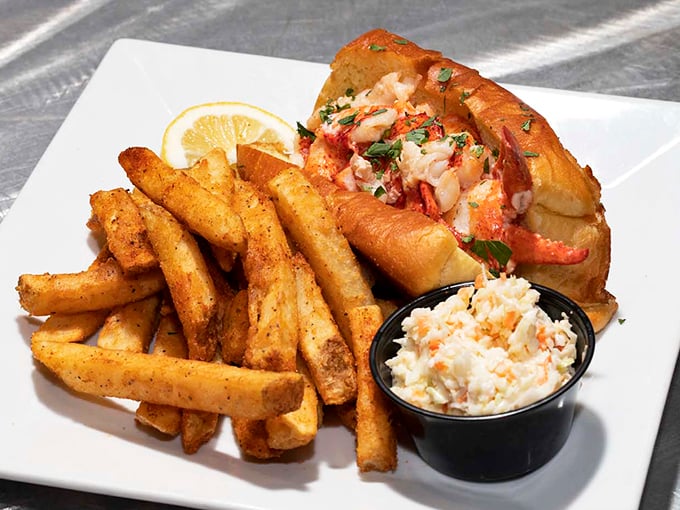 Lobster roll perfection: Buttery toasted roll cradles sweet, tender chunks of lobster meat alongside golden fries and house-made coleslaw.