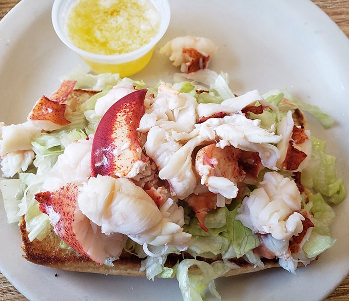 Lobster roll perfection: chunky meat, light dressing, crisp lettuce, and that buttery roll. This isn't just lunch – it's a New England vacation on a plate.