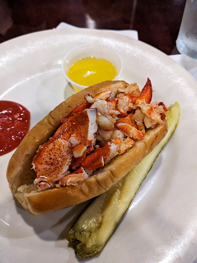 This lobster roll isn't just a sandwich, it's a vacation on a bun—chunks of sweet meat nestled in buttery perfection with a pickle standing guard.