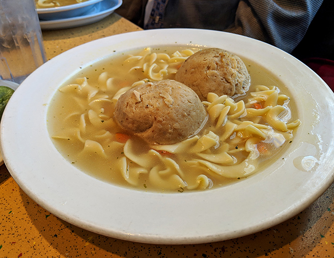 Two golden matzo balls floating in amber broth - this is what culinary therapy looks like, folks.
