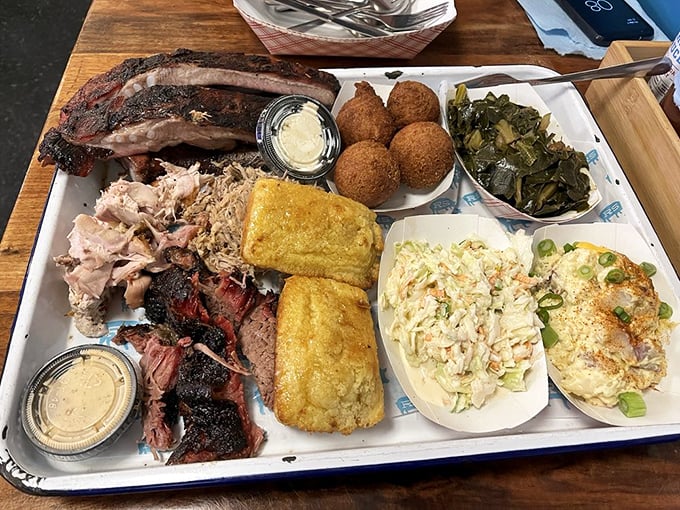 BBQ heaven on a tray: ribs with perfect bark, pulled pork with that smoke ring, cornbread, and sides that don't play second fiddle to the meat.