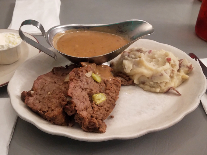 The star of the show: meatloaf that doesn't just sit on the plate—it commands attention with its savory presence and gravy boat companion. 