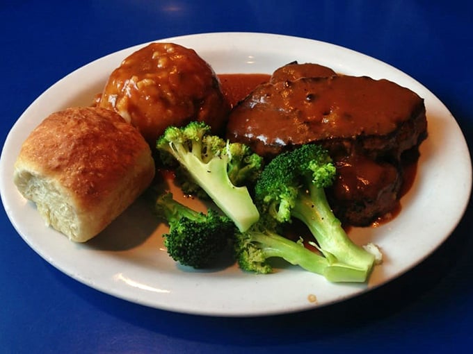 Behold the star of the show – meatloaf that would make your grandmother both jealous and proud, swimming in gravy that deserves its own fan club.