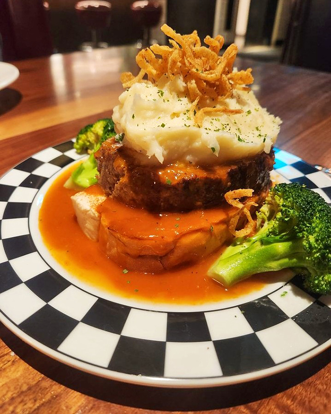 The famous meatloaf arrives like a culinary skyscraper – layers of savory perfection crowned with mashed potatoes and crispy onion straws.